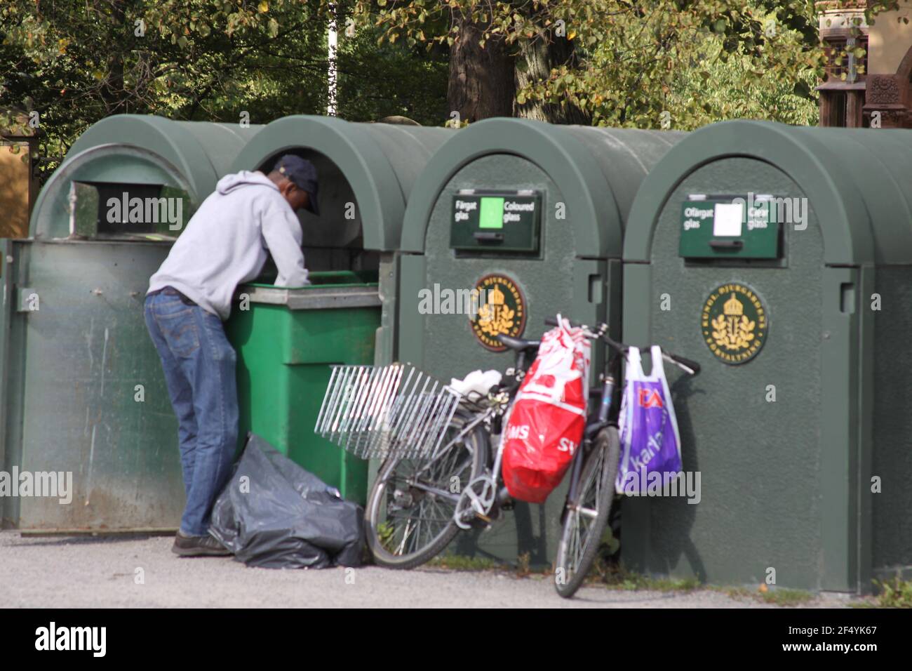 A homeless man looking threw the garbage bins Stock Photo - Alamy