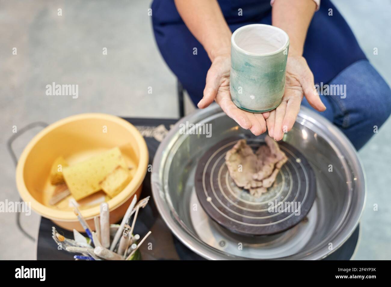 Close up shot of hands of woman holding handmade clay ceramic product ...
