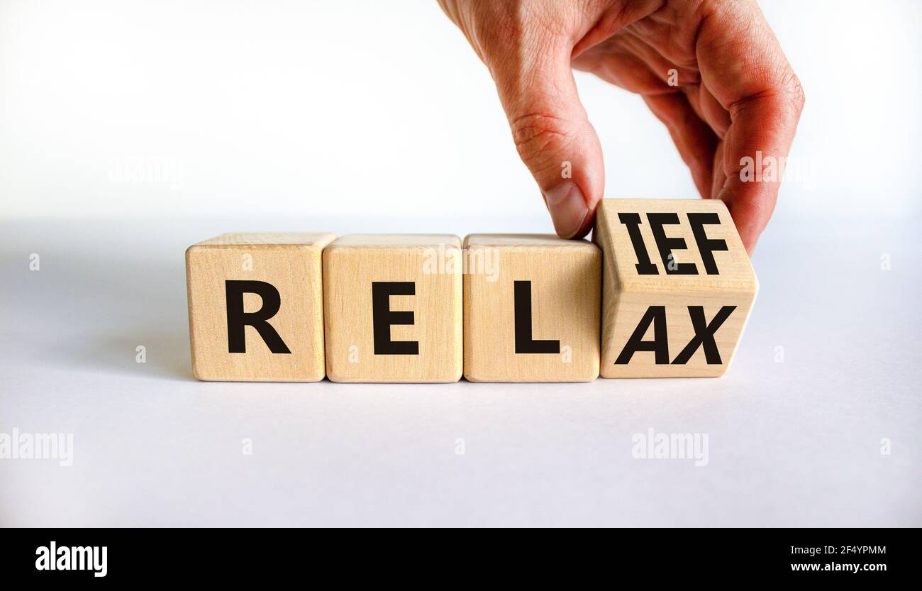 Relief and relax symbol. Businessman turns a cube and changes the word ...