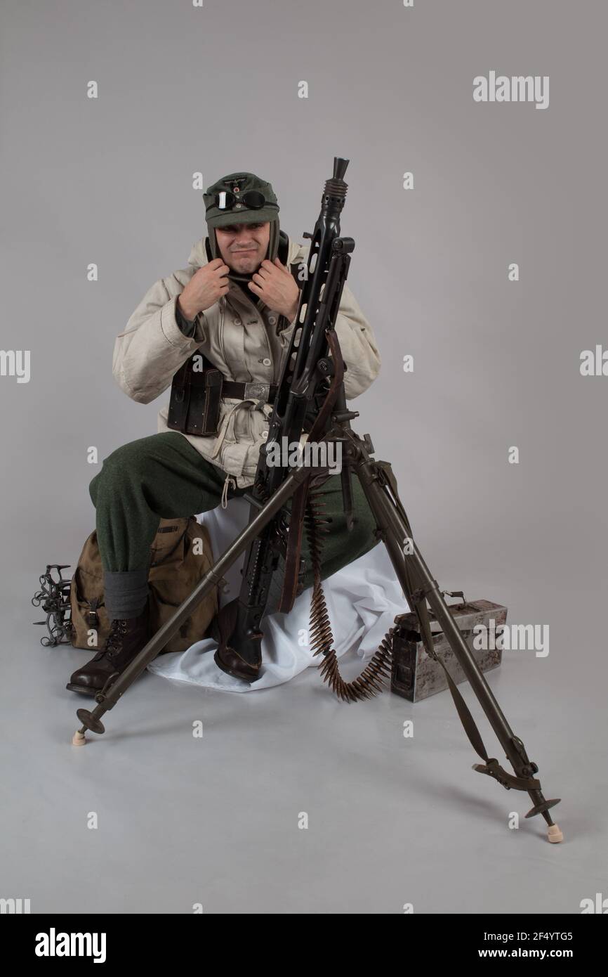 actor man in the old winter mountain uniform near the MG 42 machine gun ...
