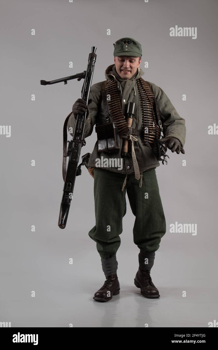 actor man in the old winter mountain uniform near the MG 42 machine gun ...