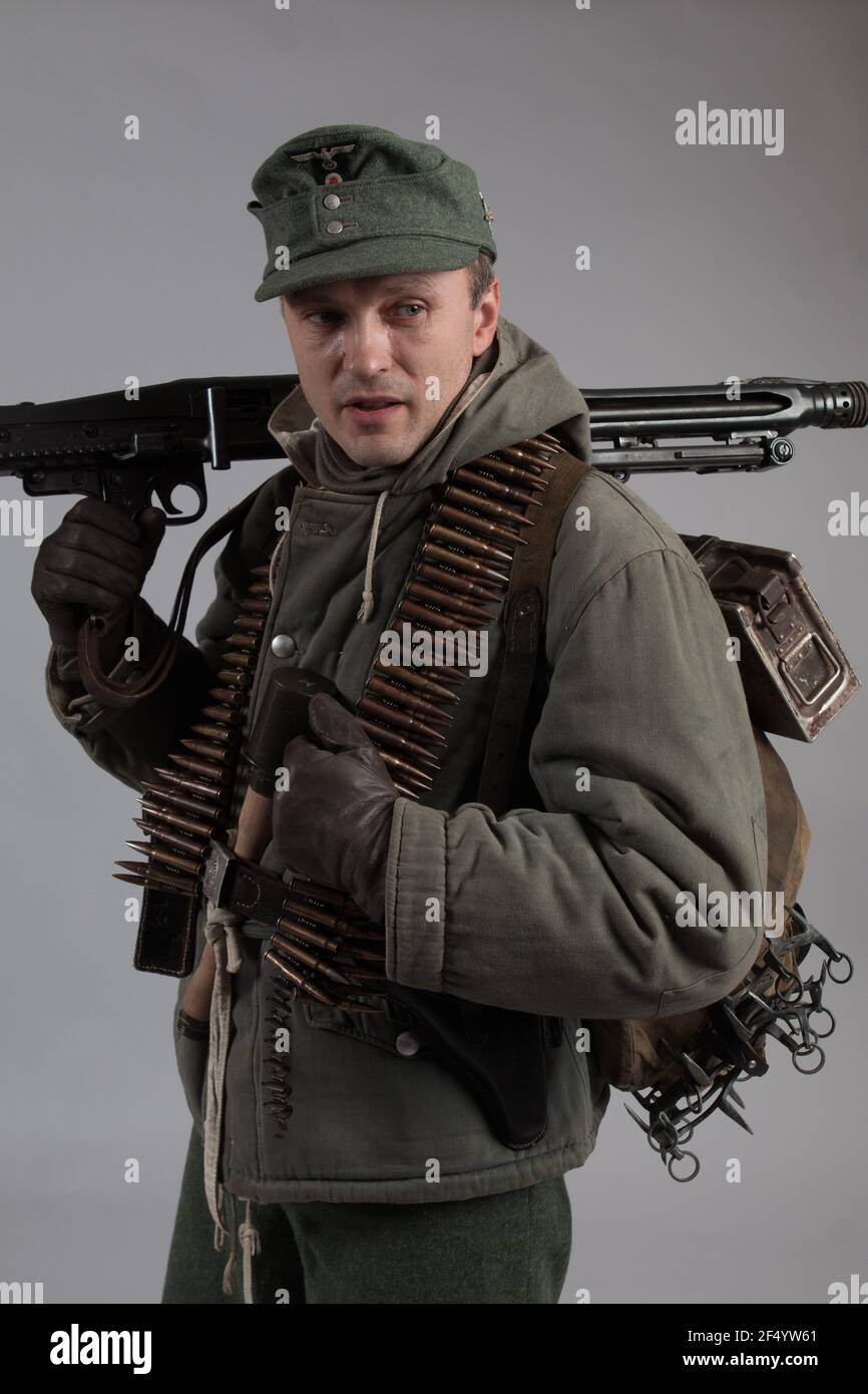 actor man in the old winter mountain uniform near the MG 42 machine gun ...