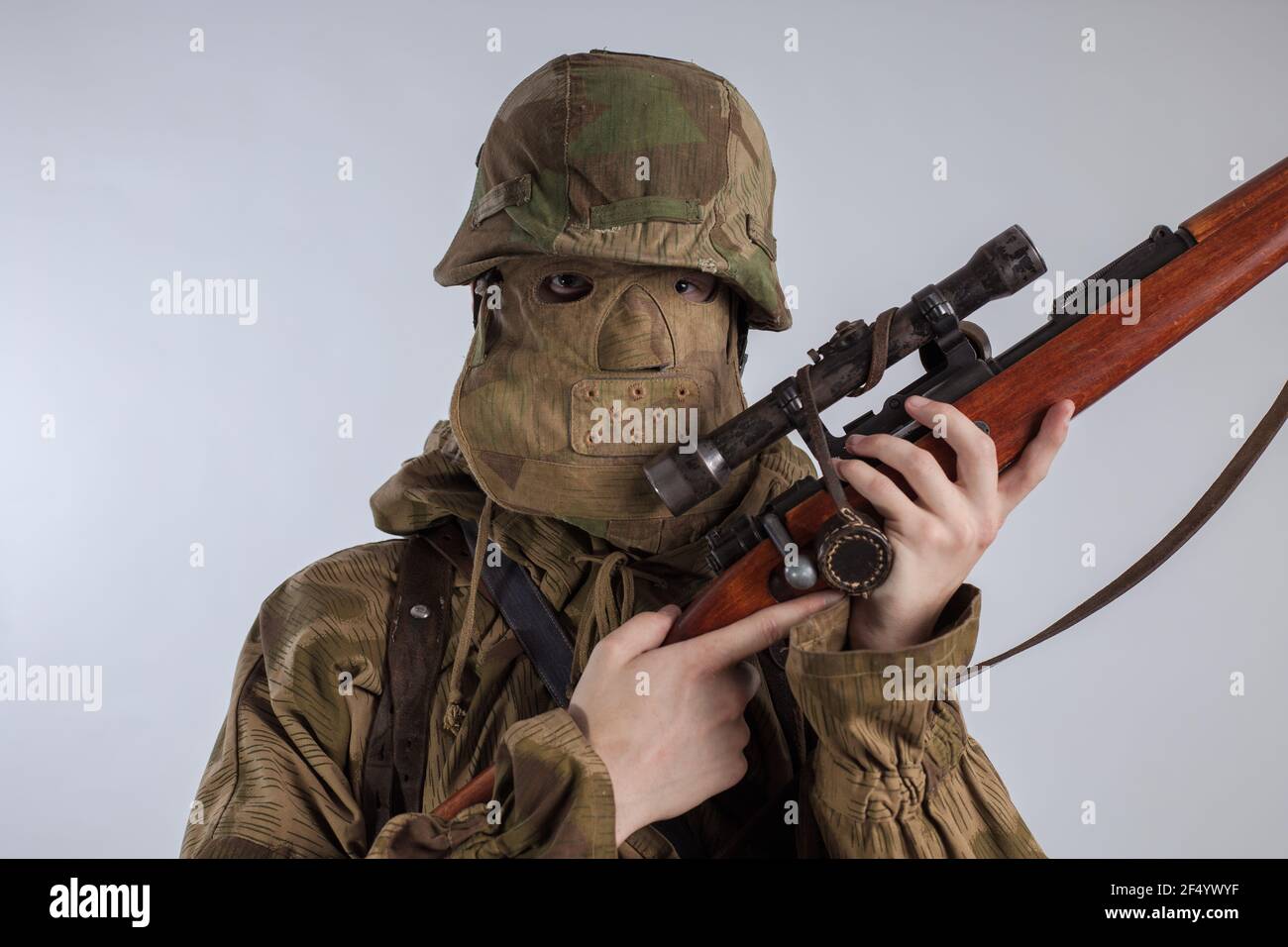 Actor man in an old military uniform and camouflage sniper marksman ...