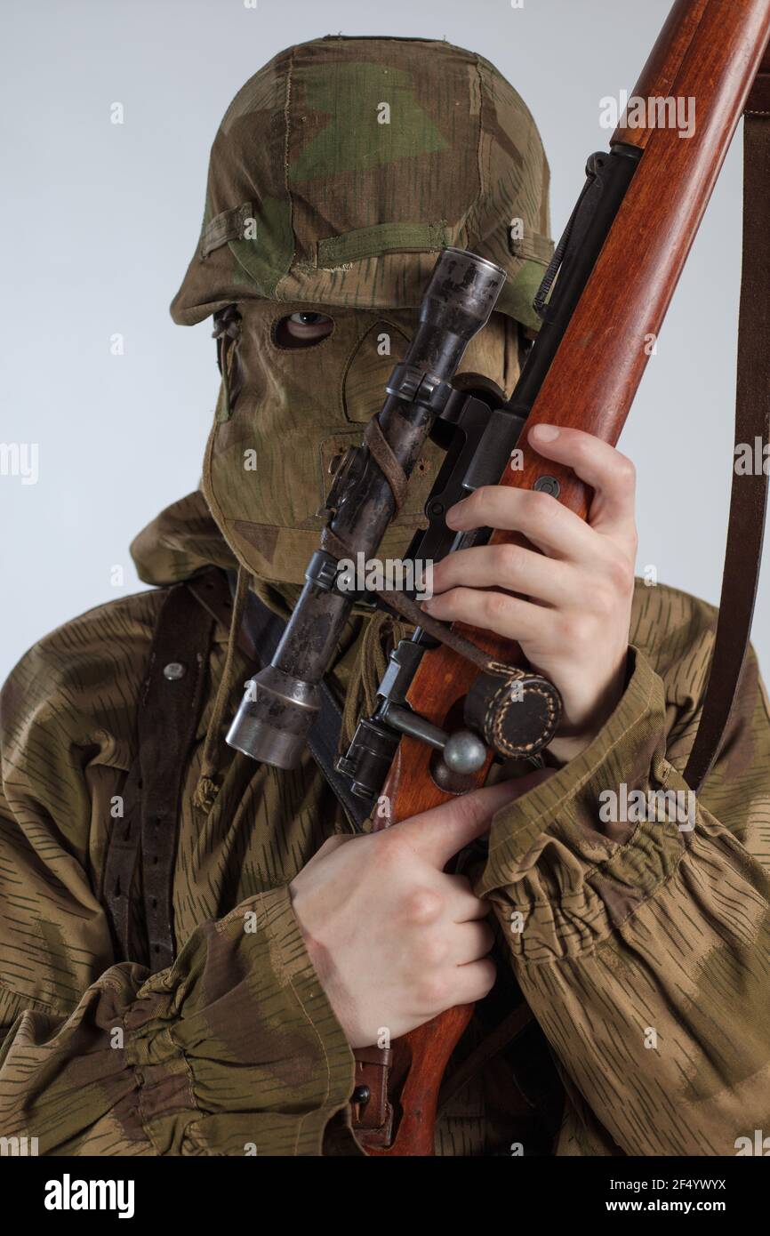 Actor man in an old military uniform and camouflage sniper marksman ...