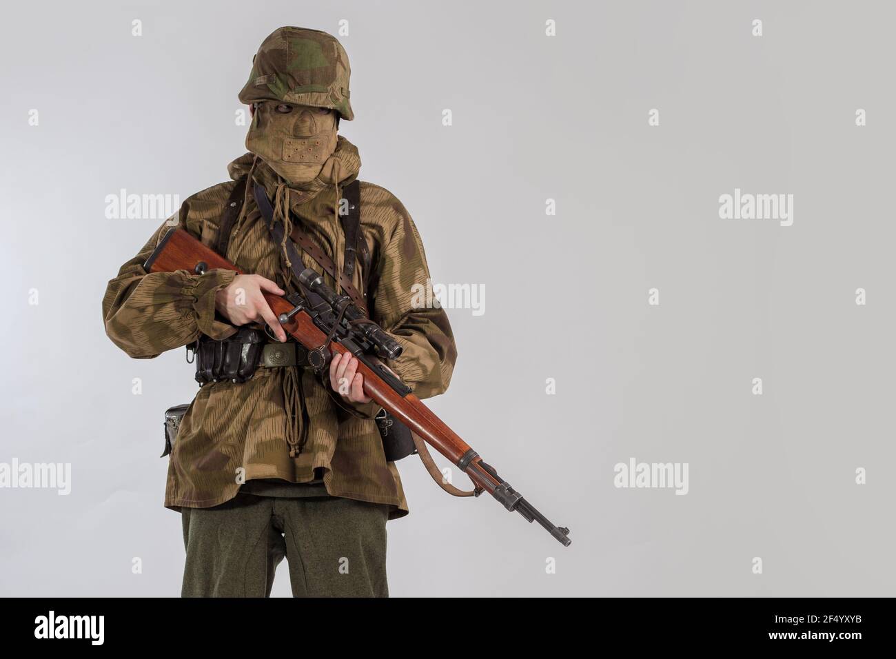 Actor man in an old military uniform and camouflage sniper marksman ...