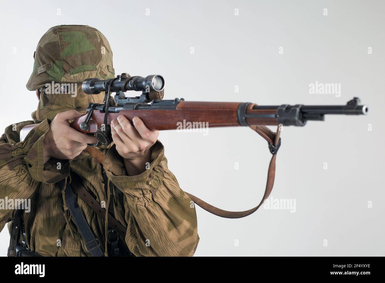 Actor man in an old military uniform and camouflage sniper marksman ...