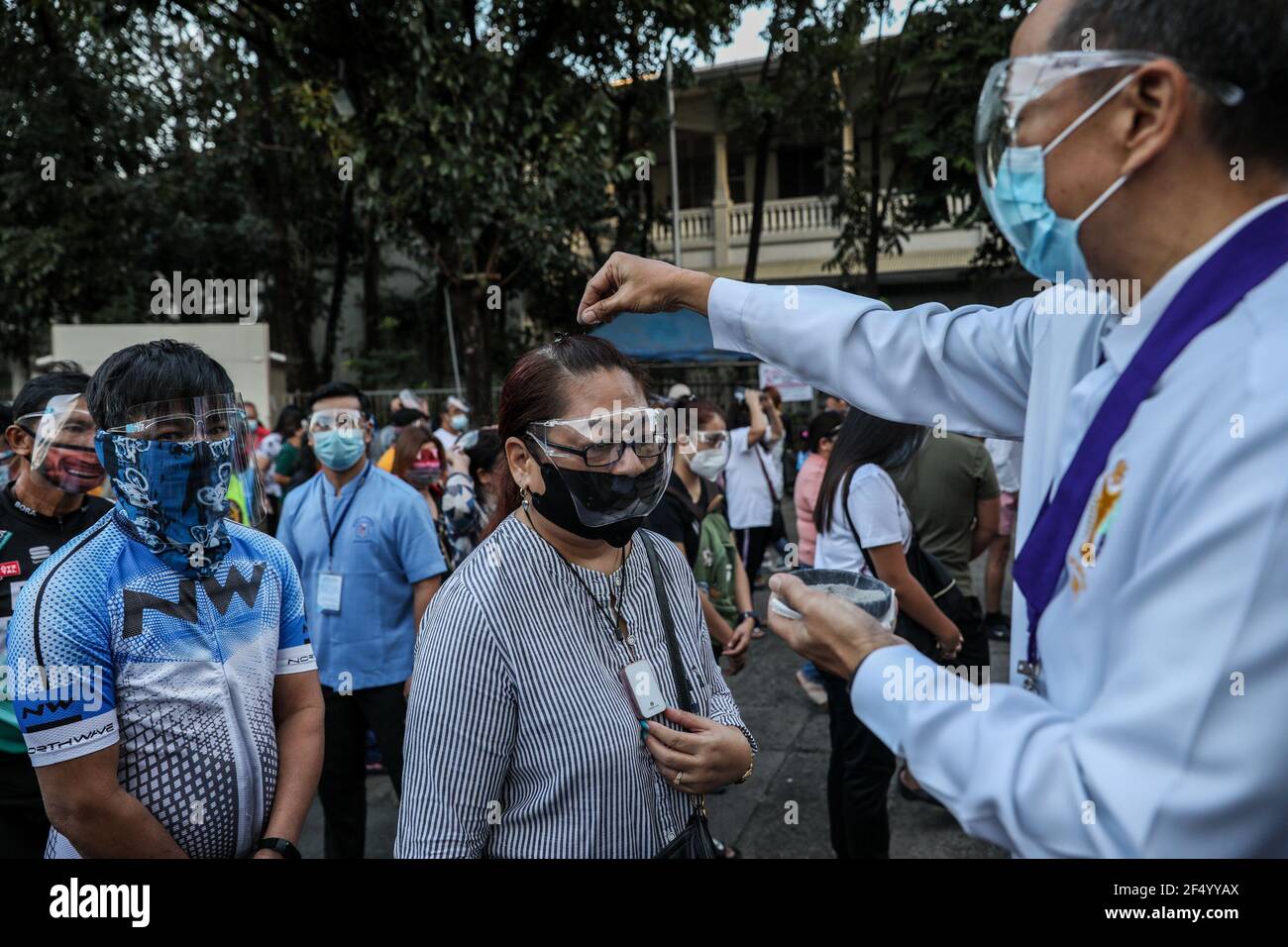 A lay minister sprinkles ash on the head of a Catholic devotee during ...