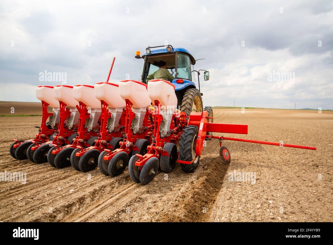 tractor sowing of seed to field at spring time Stock Photo - Alamy