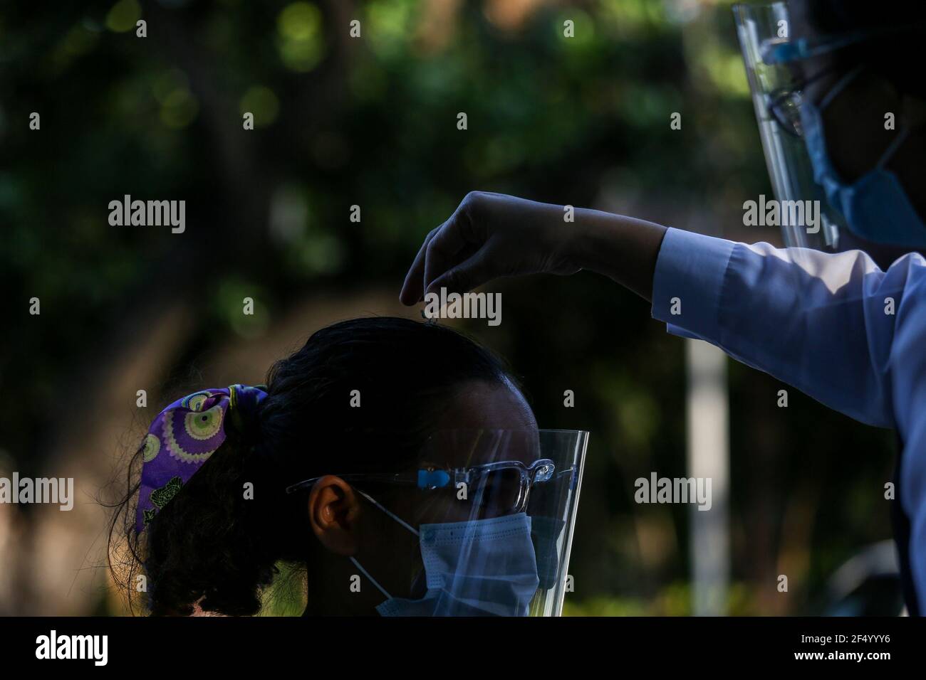 A lay minister sprinkles ash on the head of a Catholic devotee during ...