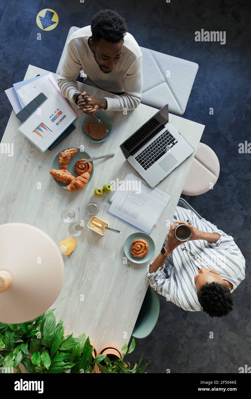 Business people talking over breakfast at office table Stock Photo - Alamy