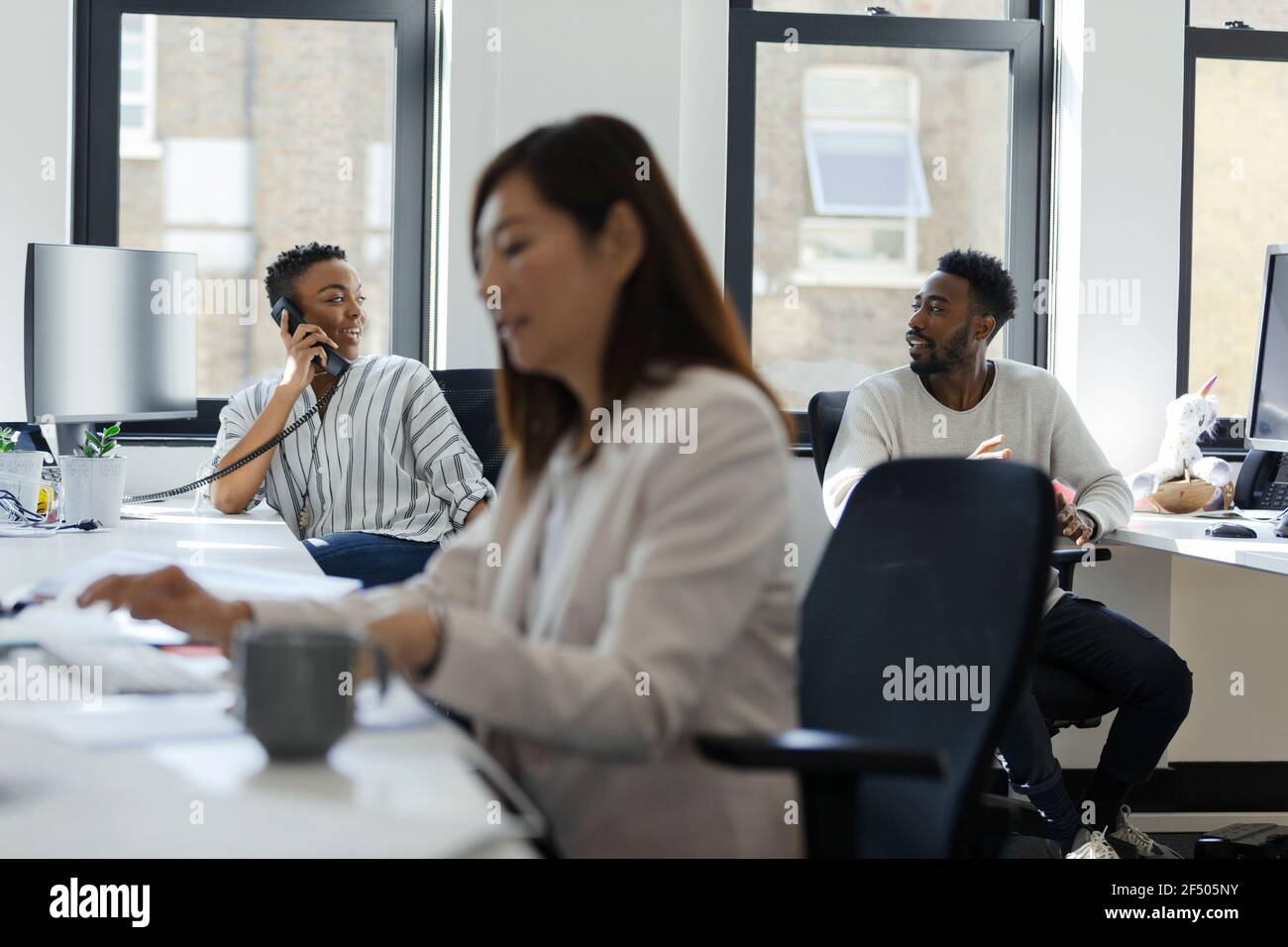 Business people working and talking in open plan office Stock Photo - Alamy