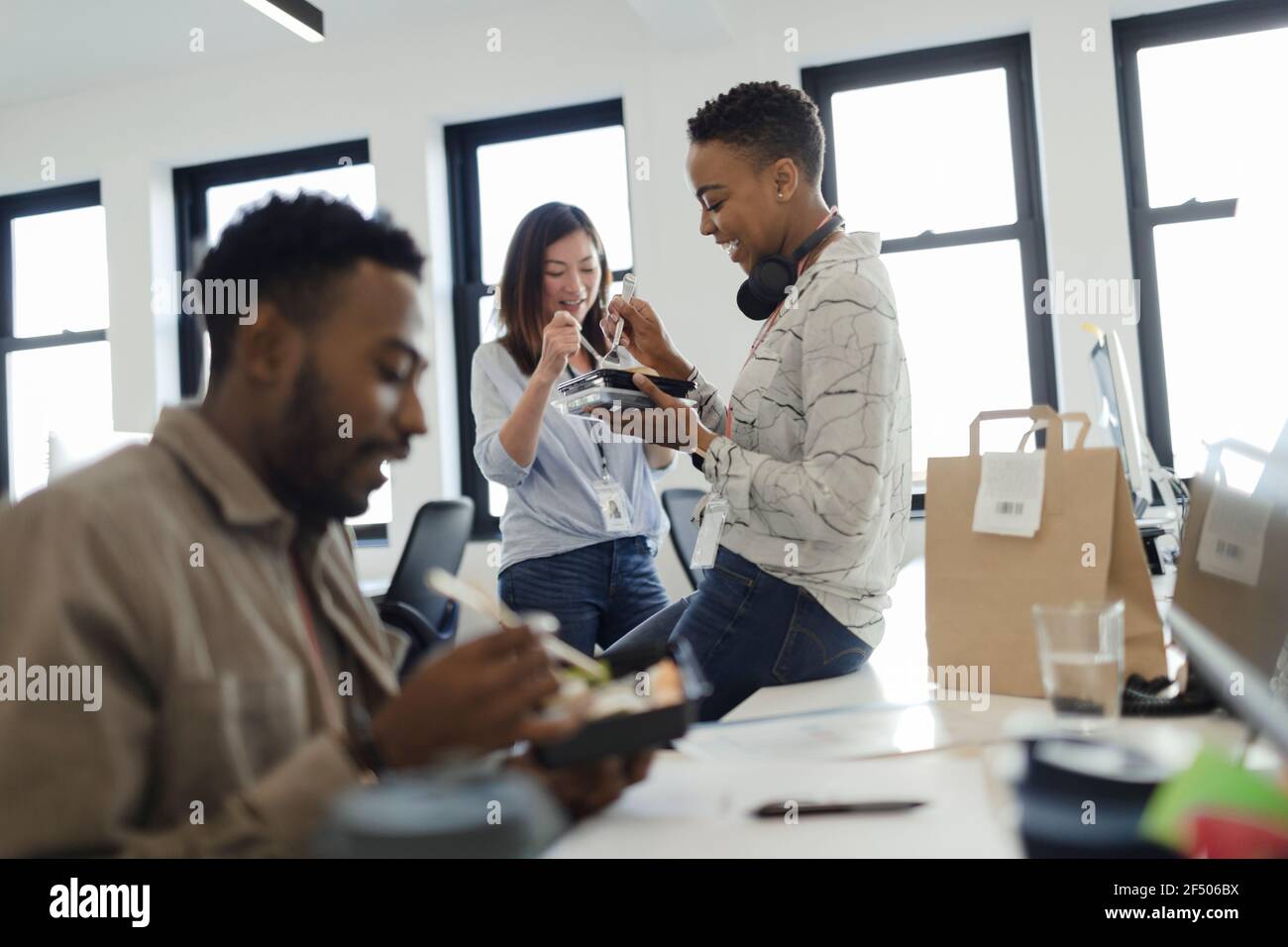 Business people eating takeout lunch at desk in office Stock Photo - Alamy