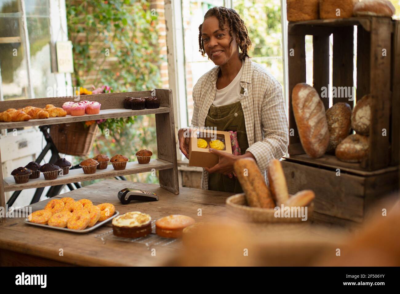 Portrait proud female baker boxing pastries in shop Stock Photo - Alamy