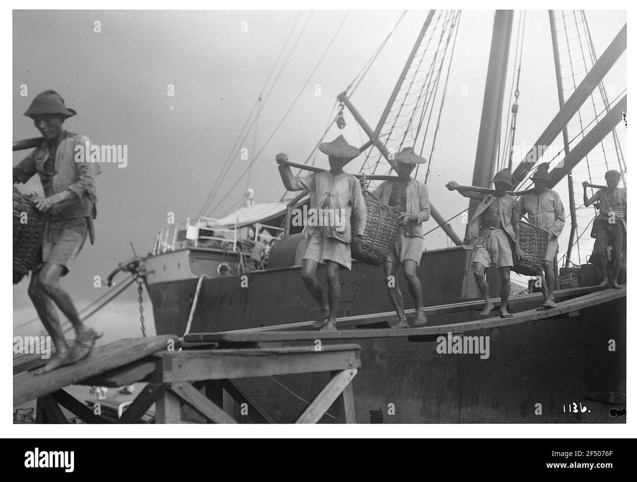 Worker when unloading a ship with carrying boys, maybe in Singapore ...