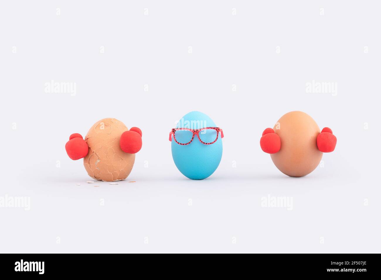 Closeup shot of eggs with boxing gloves and a referee on a white ...