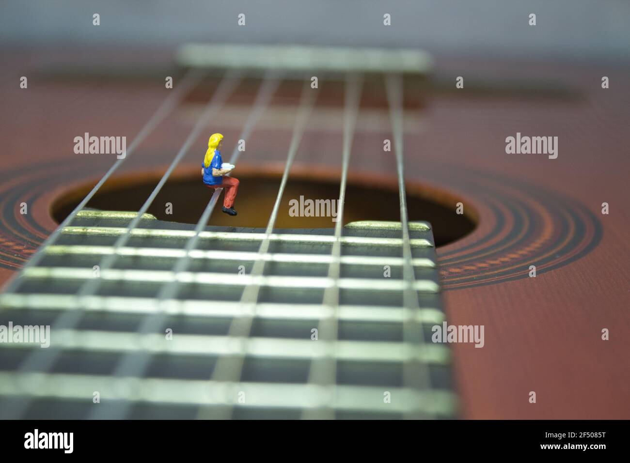 Closeup shot of a small figure of a person on a classical guitar Stock ...