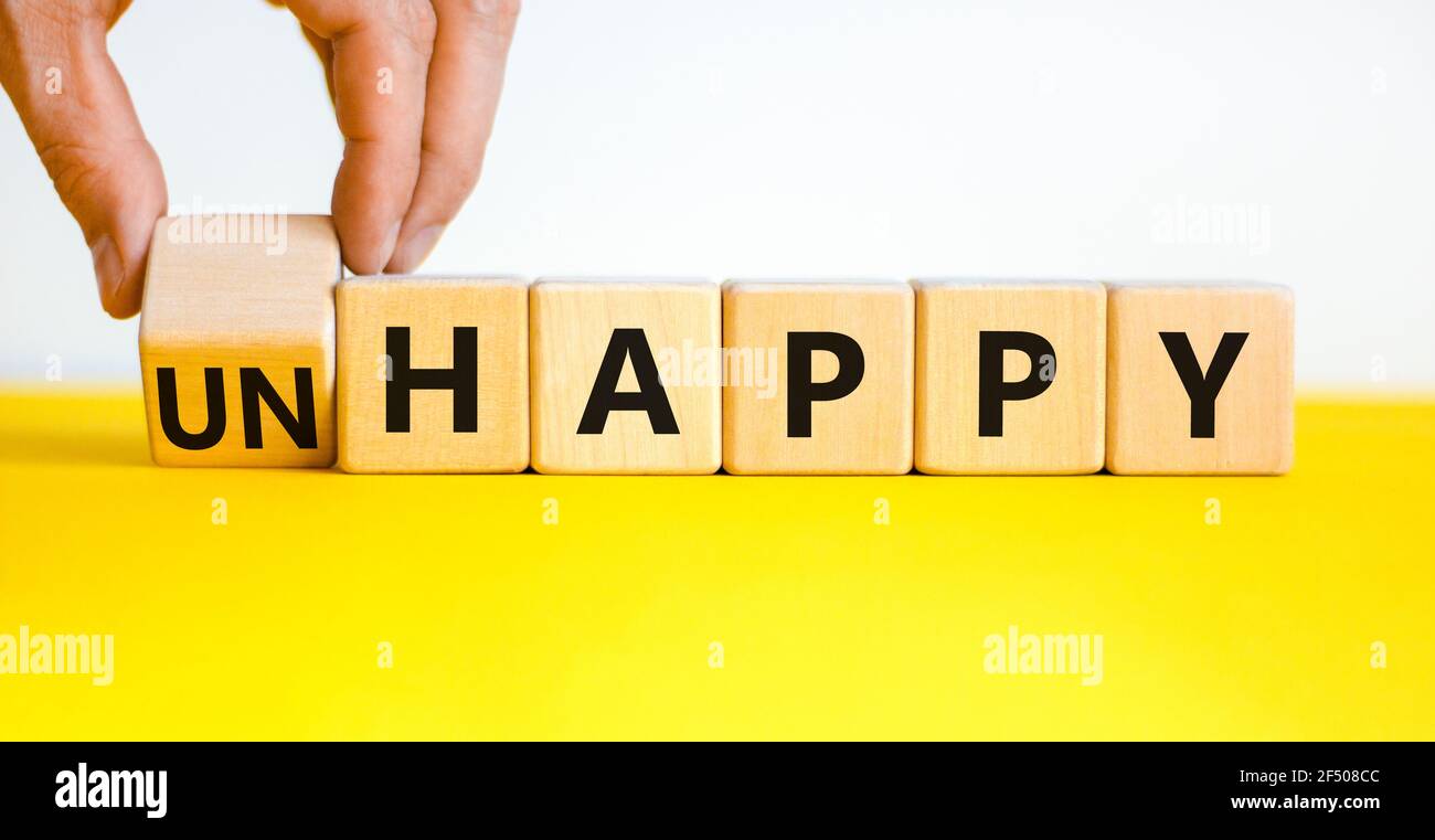 Be happy, do not unhappy symbol. Businessman turns the wooden cube and ...