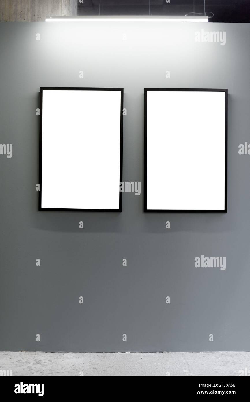 Mock up. Blank picture frames on gray wall in the loft interior ...