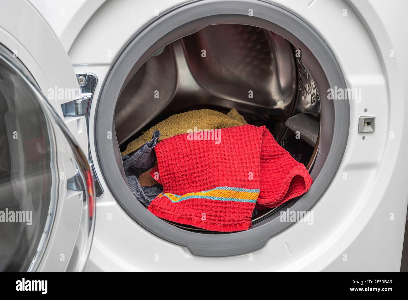 Close up view of washed laundry in a laundry machine. Home routine ...