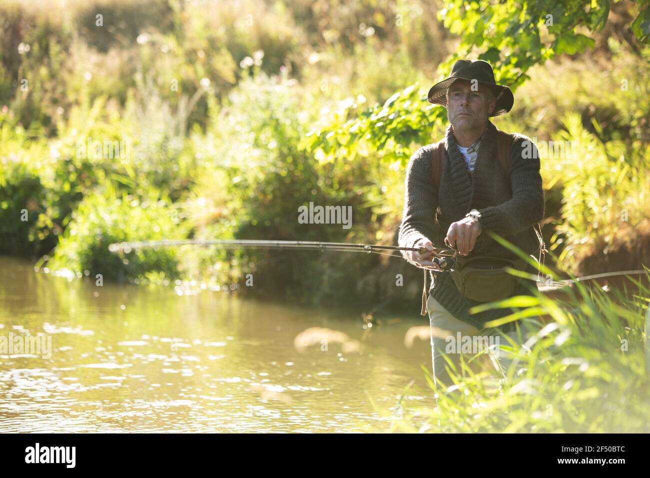 Man fly fishing at sunny river Stock Photo - Alamy