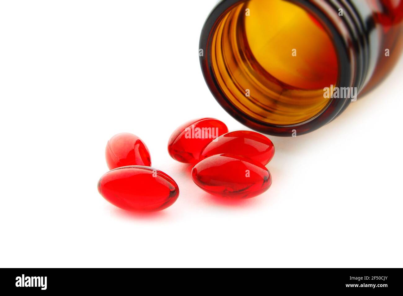 Red vitamin pills in vial isolated on white background Stock Photo - Alamy