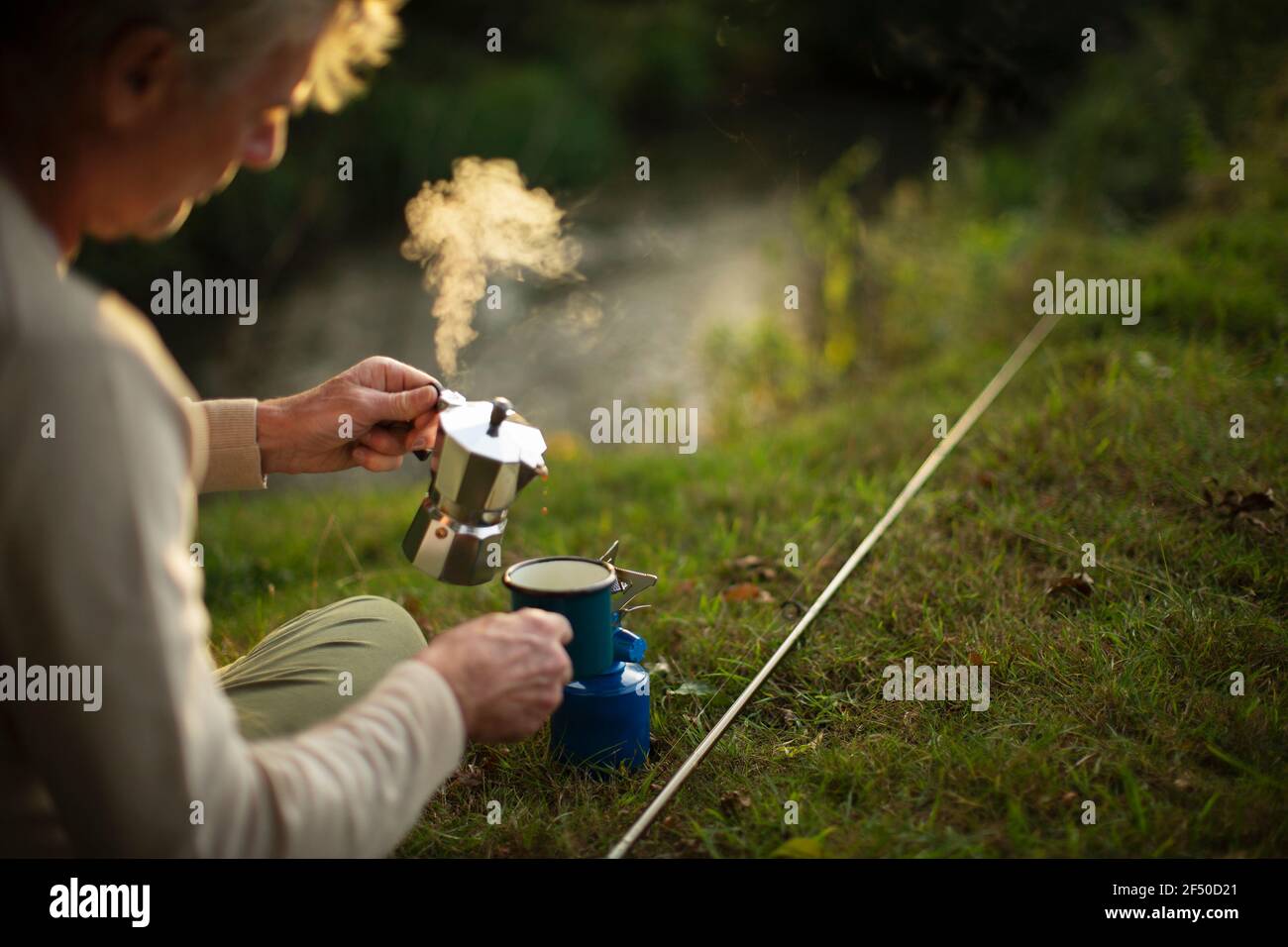 Man taking a break from fishing making hot coffee at riverbank Stock ...