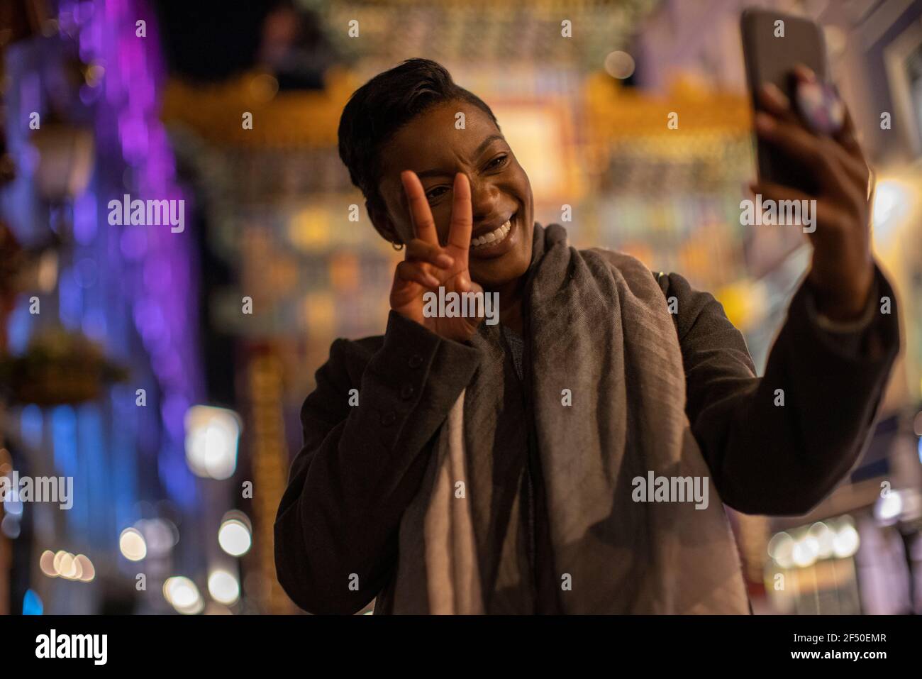 Beautiful woman gesturing peace sign hi-res stock photography and ...