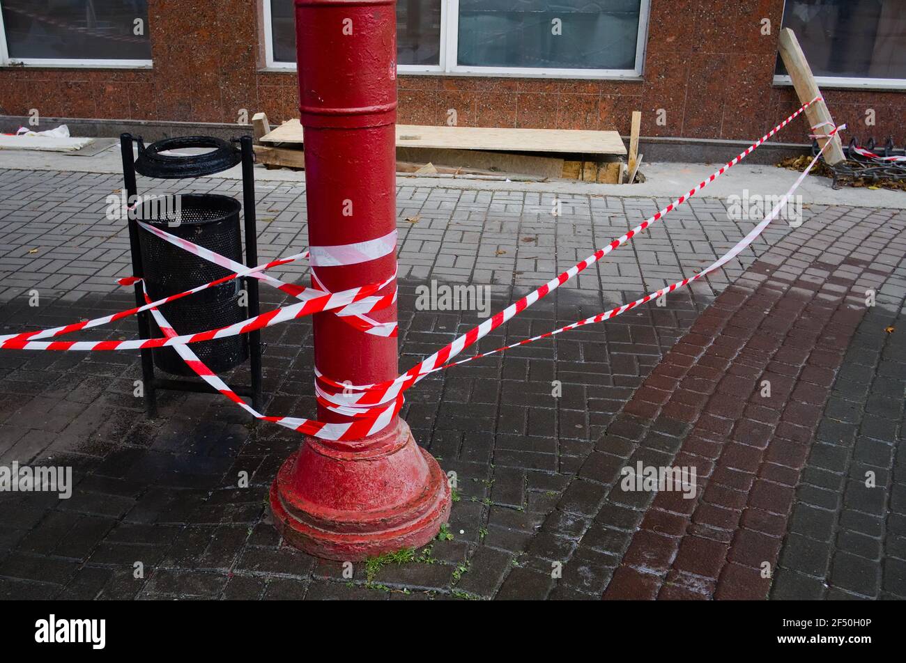 Red and white striped plastic tape restrict access to construction site ...