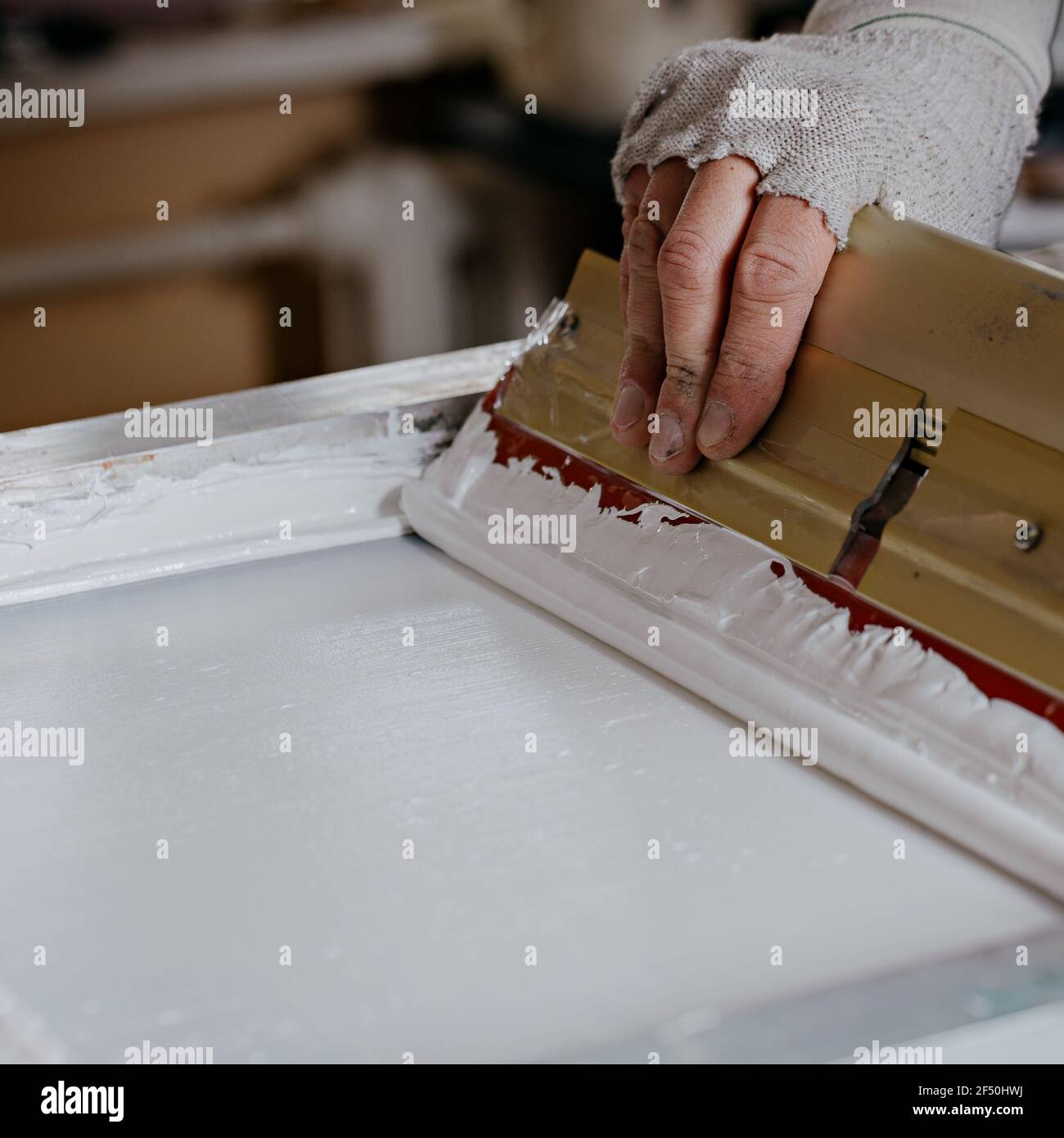 selective focus photo of male hand with squeegee. serigraphy production ...