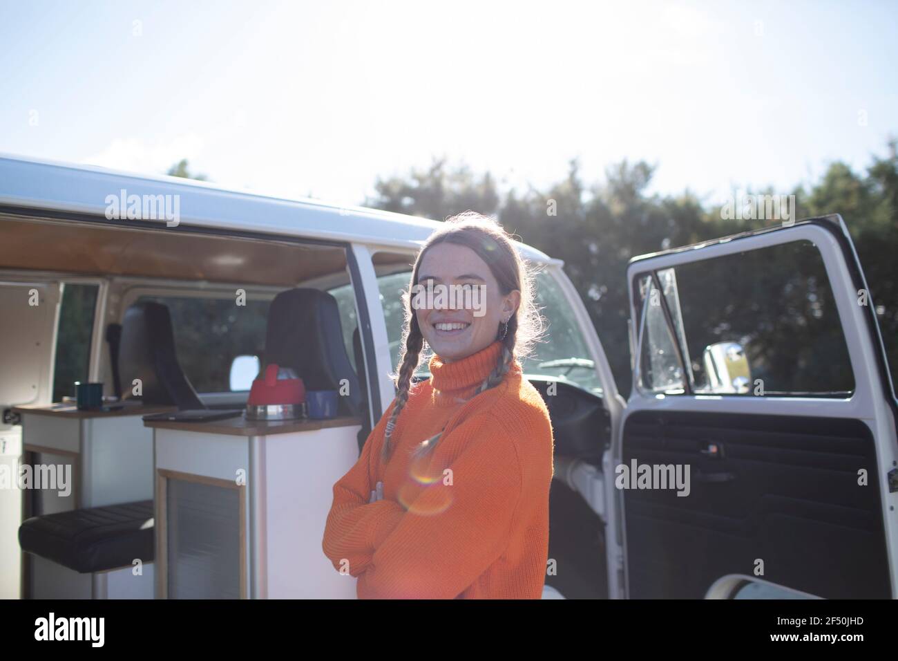 Portrait happy young woman outside sunny camper van Stock Photo - Alamy