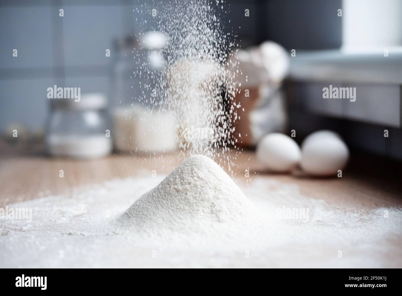 Sifting wheat flour in the kitchen with a sieve, cooking at home, close ...