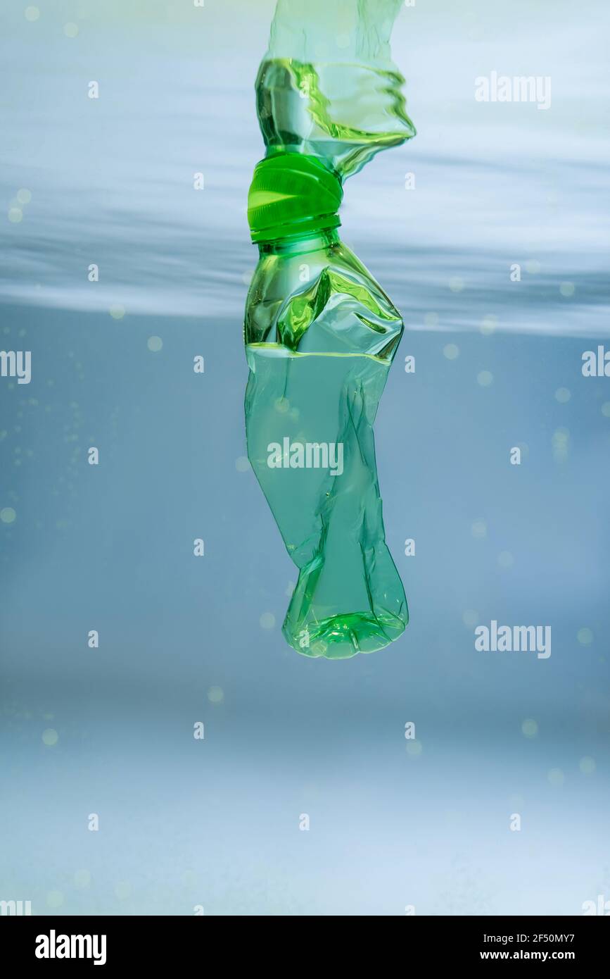 crumpled plastic bottle in water, ecology concept Stock Photo - Alamy