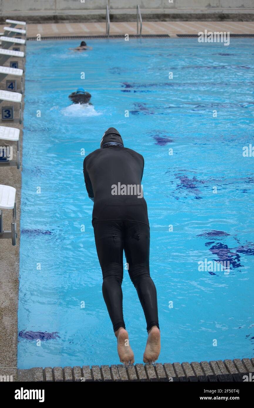 Back view of a swimmer jumping into the water Stock Photo - Alamy