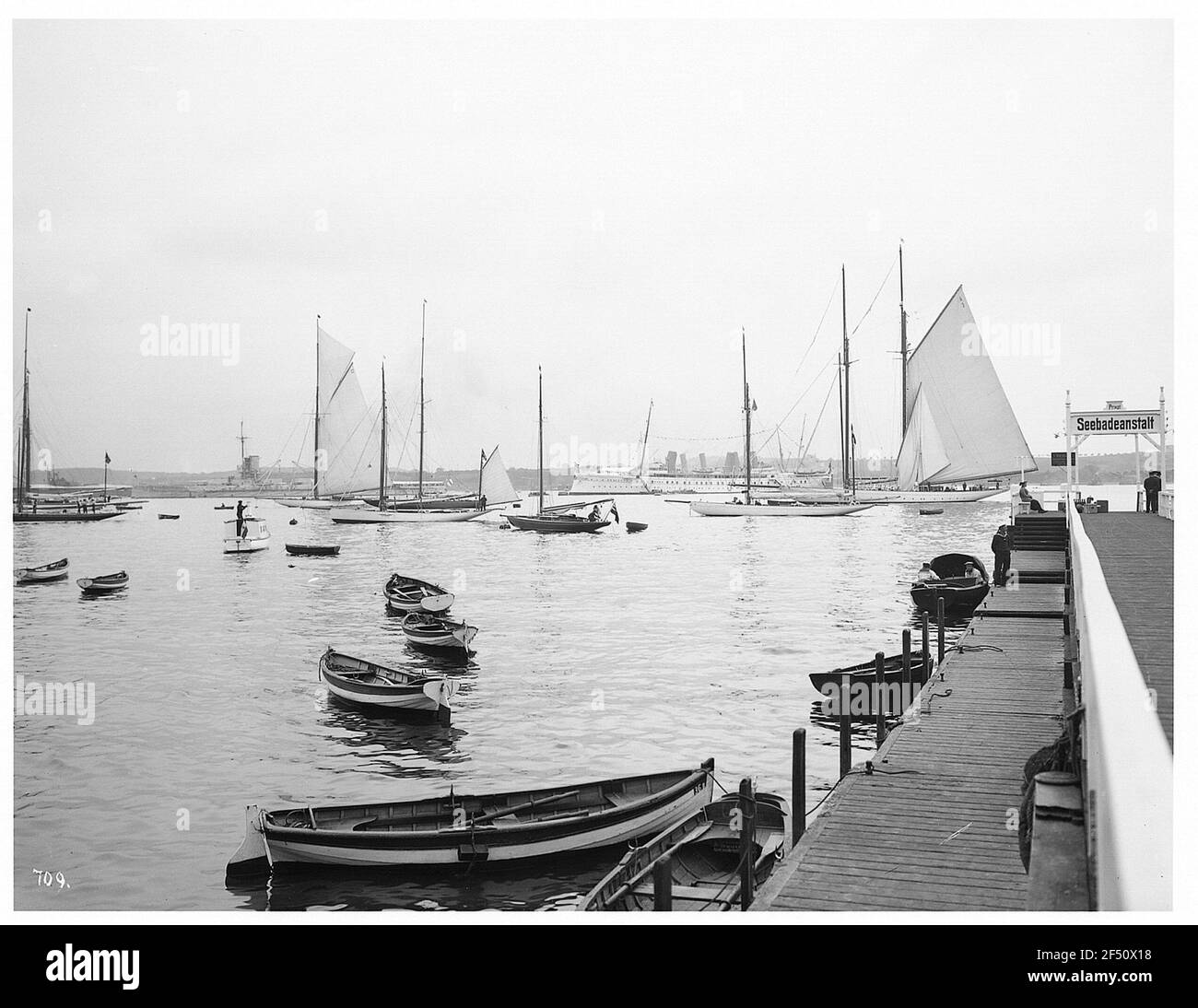 Germany. Harbor with rowing and sailboats, in the background a high-sea ...