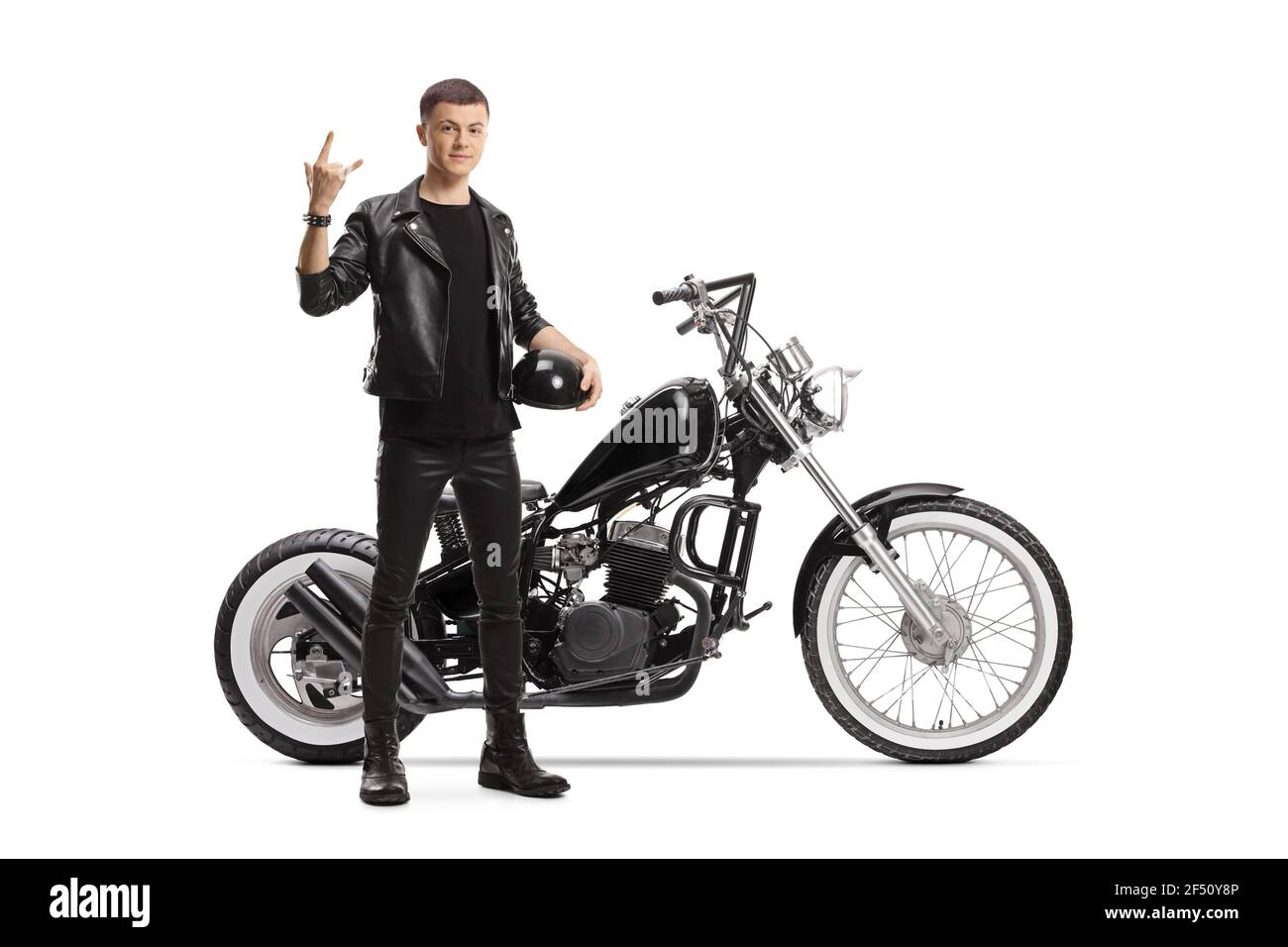 Full length portrait of a biker gesturing rock and roll sign and posing ...