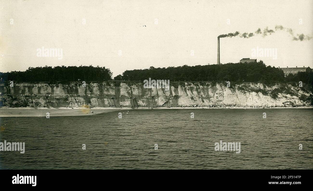 Wooded cliff coast with factory Stock Photo - Alamy