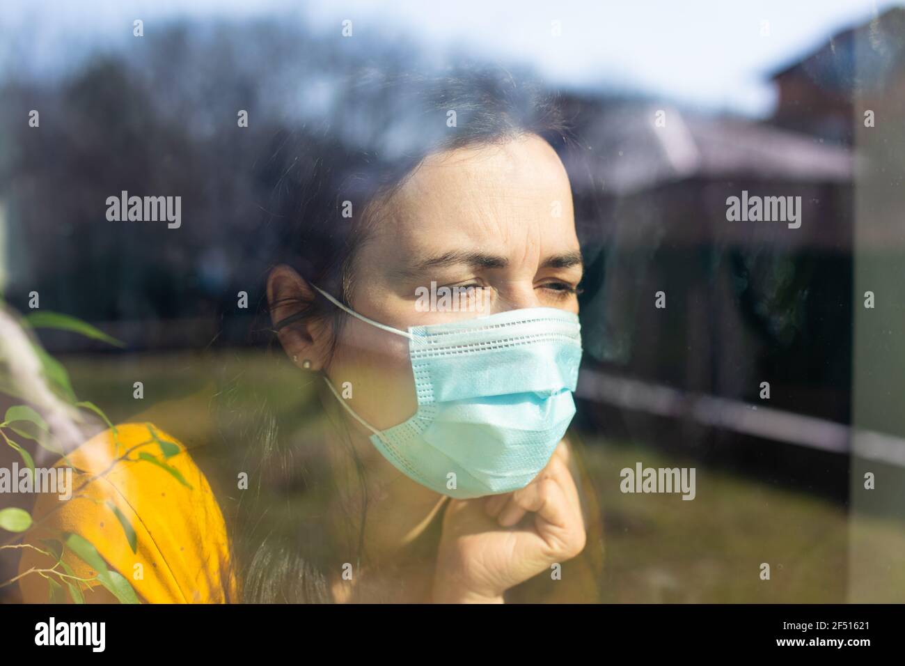 the young woman is looking through the window on sunny day Stock Photo ...