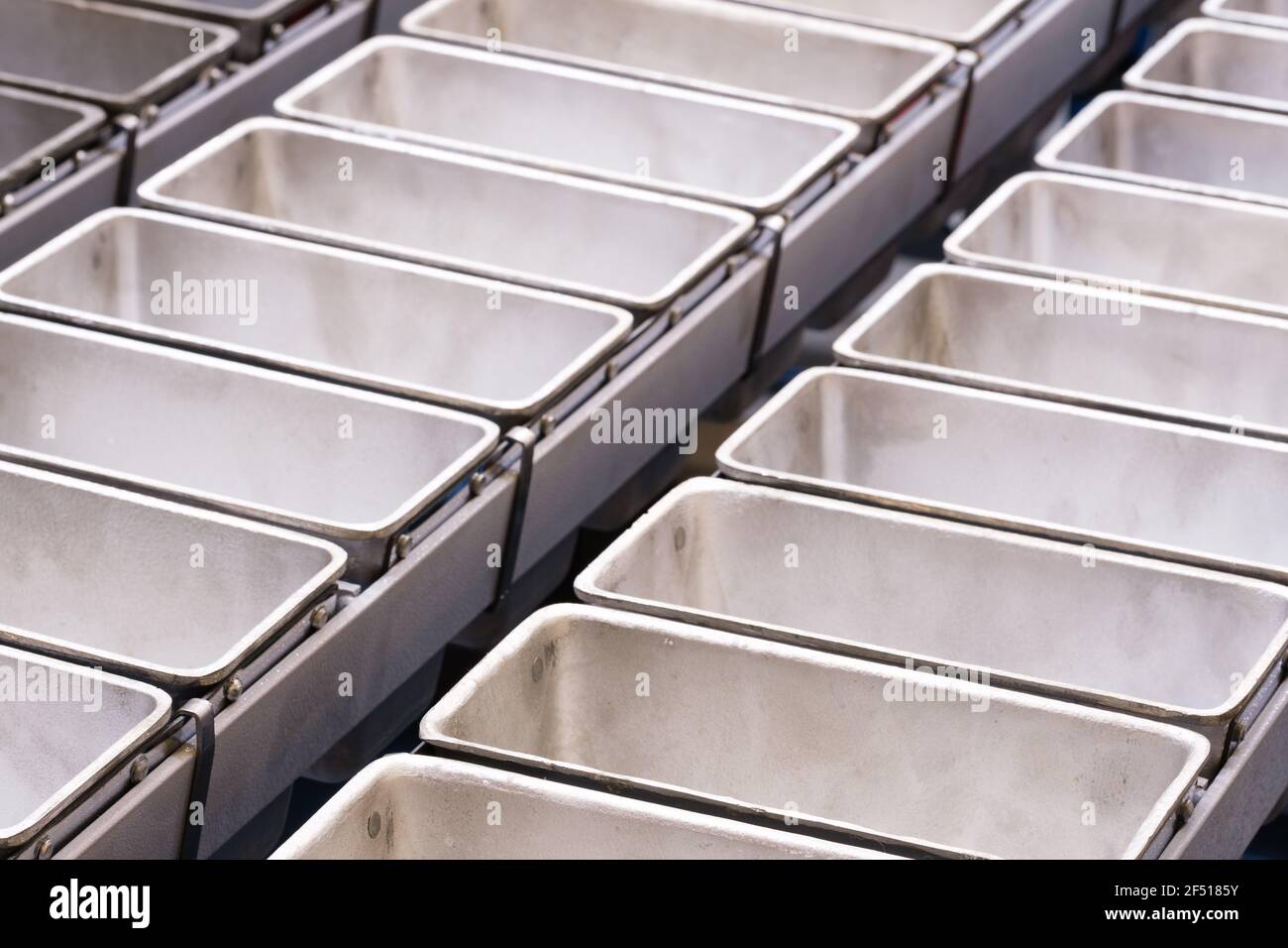 Industrial bakery automated line. Filling metal molds for baking bread ...