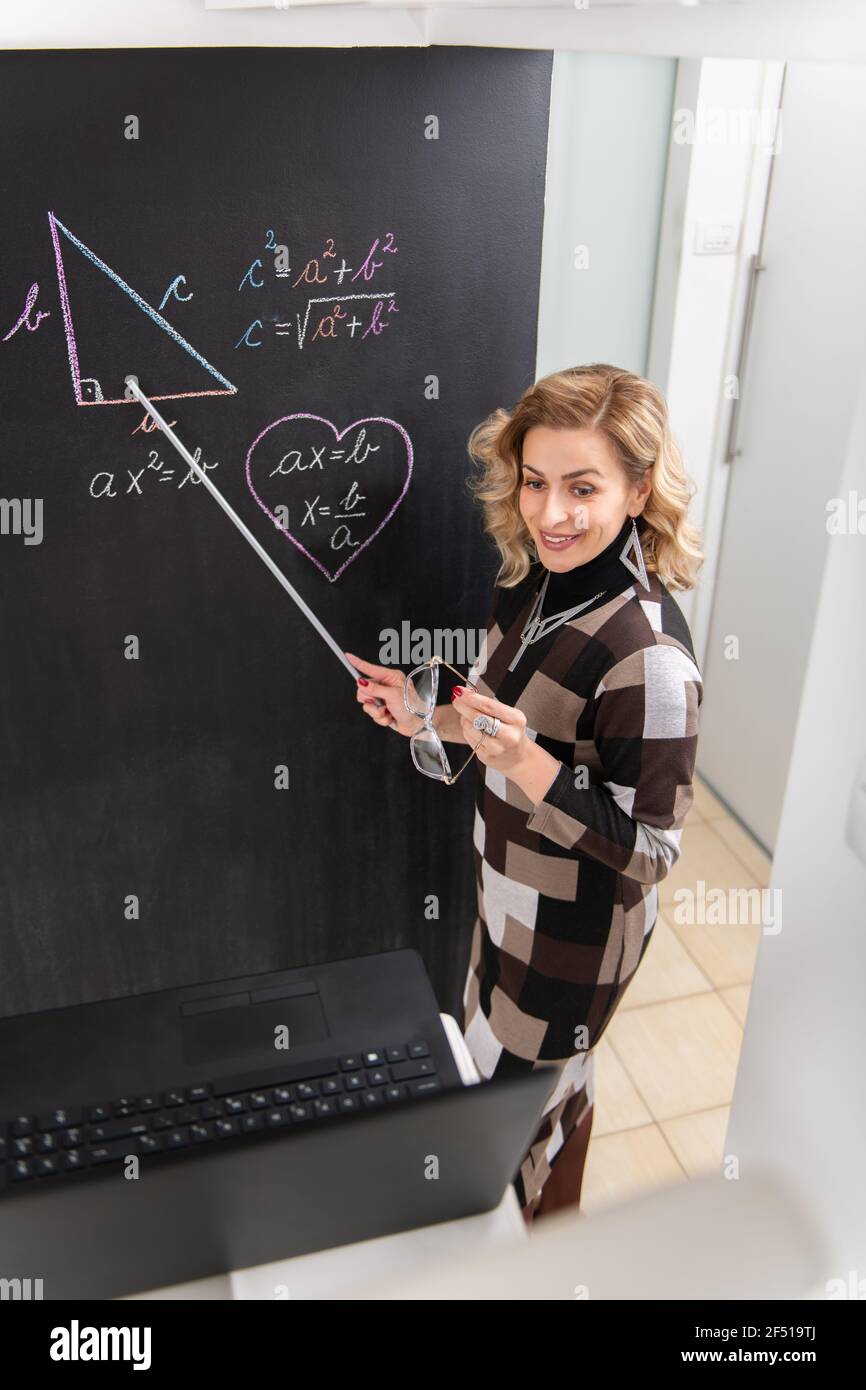 Young female math teacher explaining geometry on the black wall Stock ...