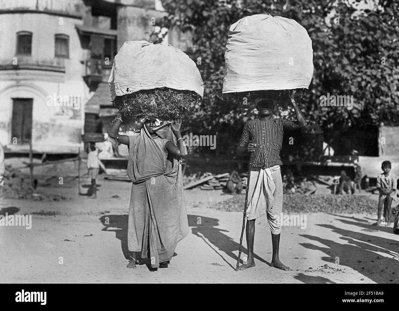 At Benares (India). Two load carrier with load on the head At Benares ...
