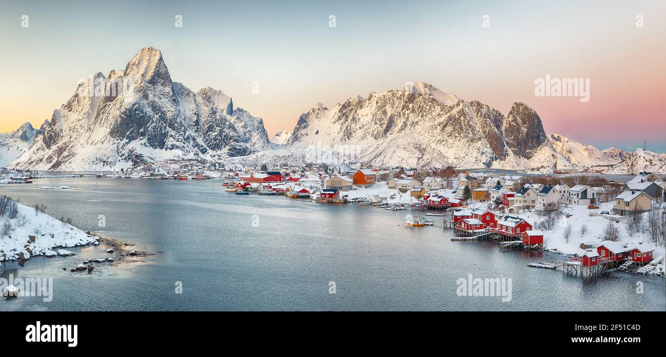 Dramatic evening cityscape of Reine town. Red rorbuers on the shore of ...