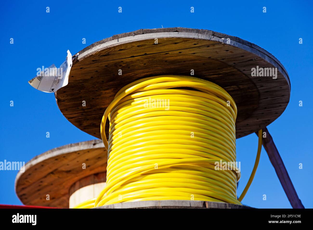 large wooden rolls with yellow wires wrapped around Stock Photo - Alamy
