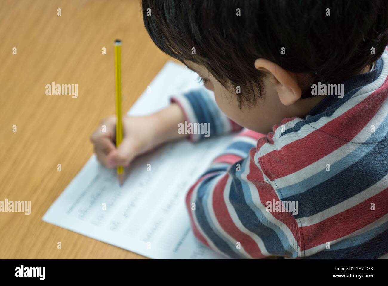 Image of boy doing homework from left side wearing red white and blue ...