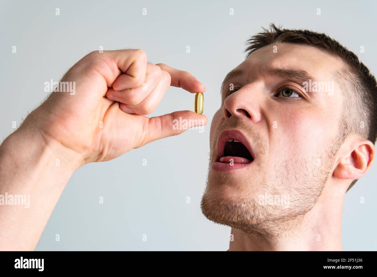 Fish oil is eaten by a man in the hands of vials and a glass bottle ...