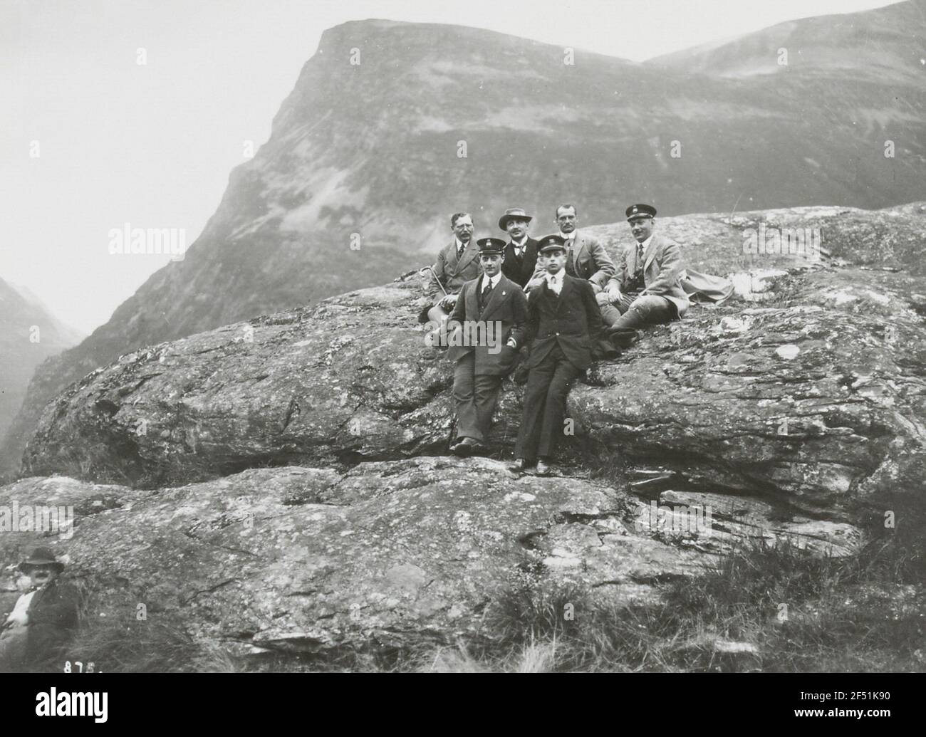 Six men's sitting on a rock Stock Photo - Alamy