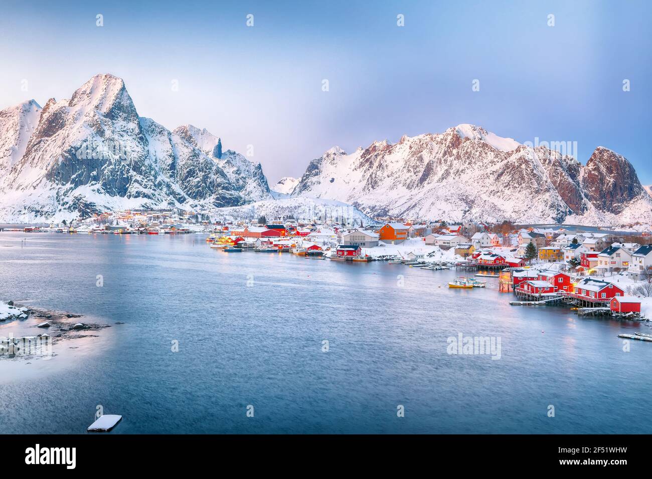 Dramatic evening cityscape of Reine town. Red rorbuers on the shore of ...