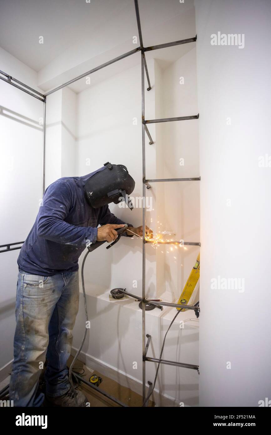 Worker welding a dressing room in a home renovation Stock Photo - Alamy