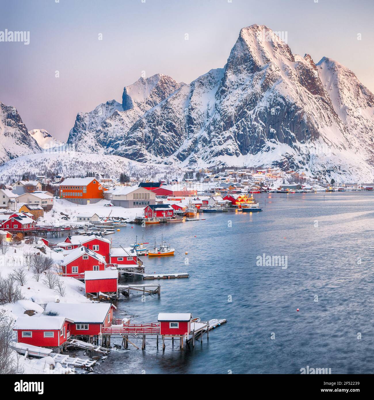 Dramatic evening cityscape of Reine town. Red rorbuers on the shore of ...