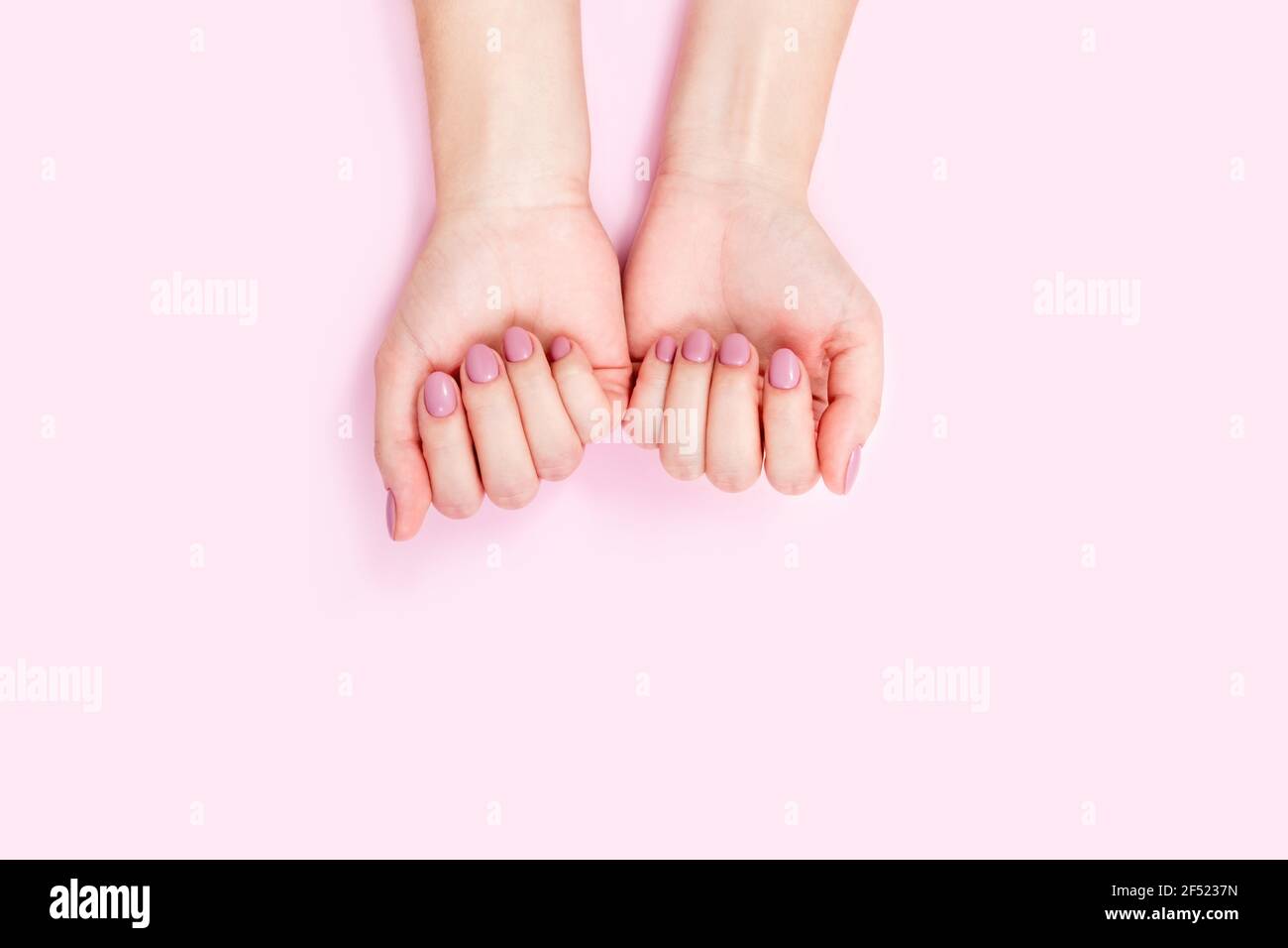 Beautiful female hands on a pink background Stock Photo - Alamy