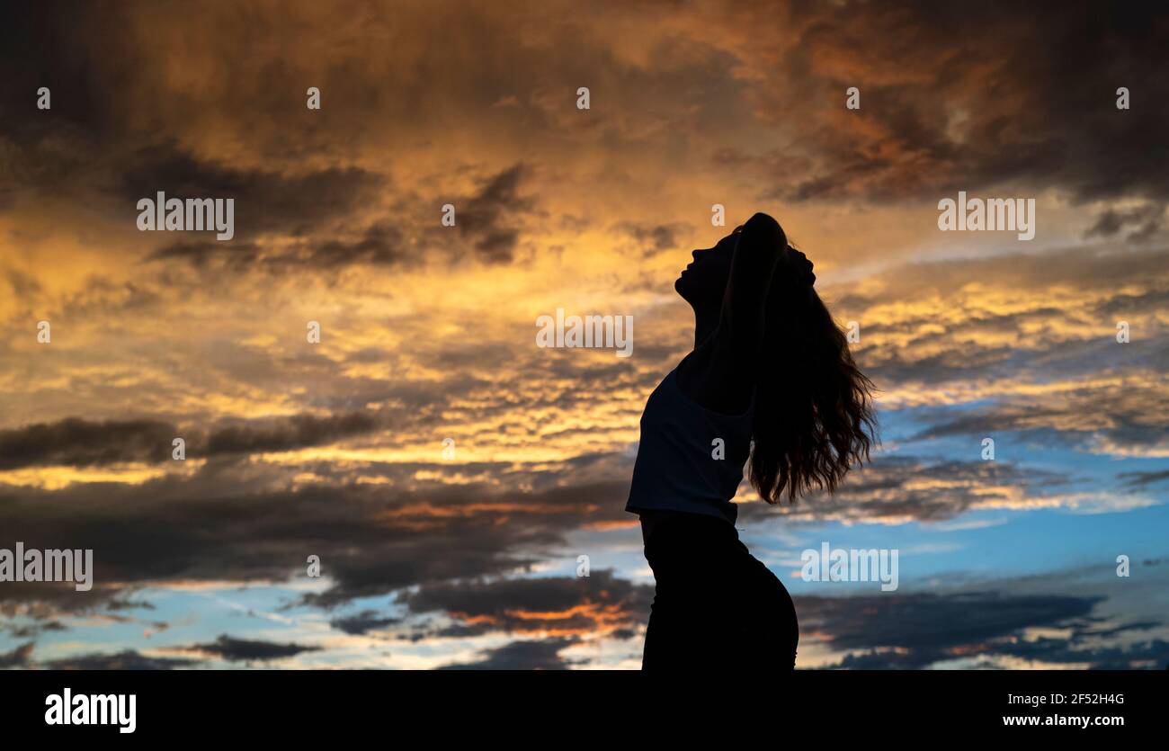 Young woman dancing in summer sunset sky outdoor. People freedom style ...